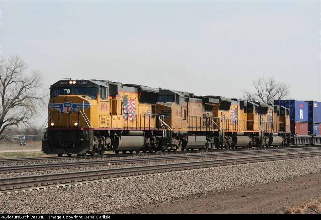 UP 4994 leads a WB mixed stack past Windmill Rd @ 13:06